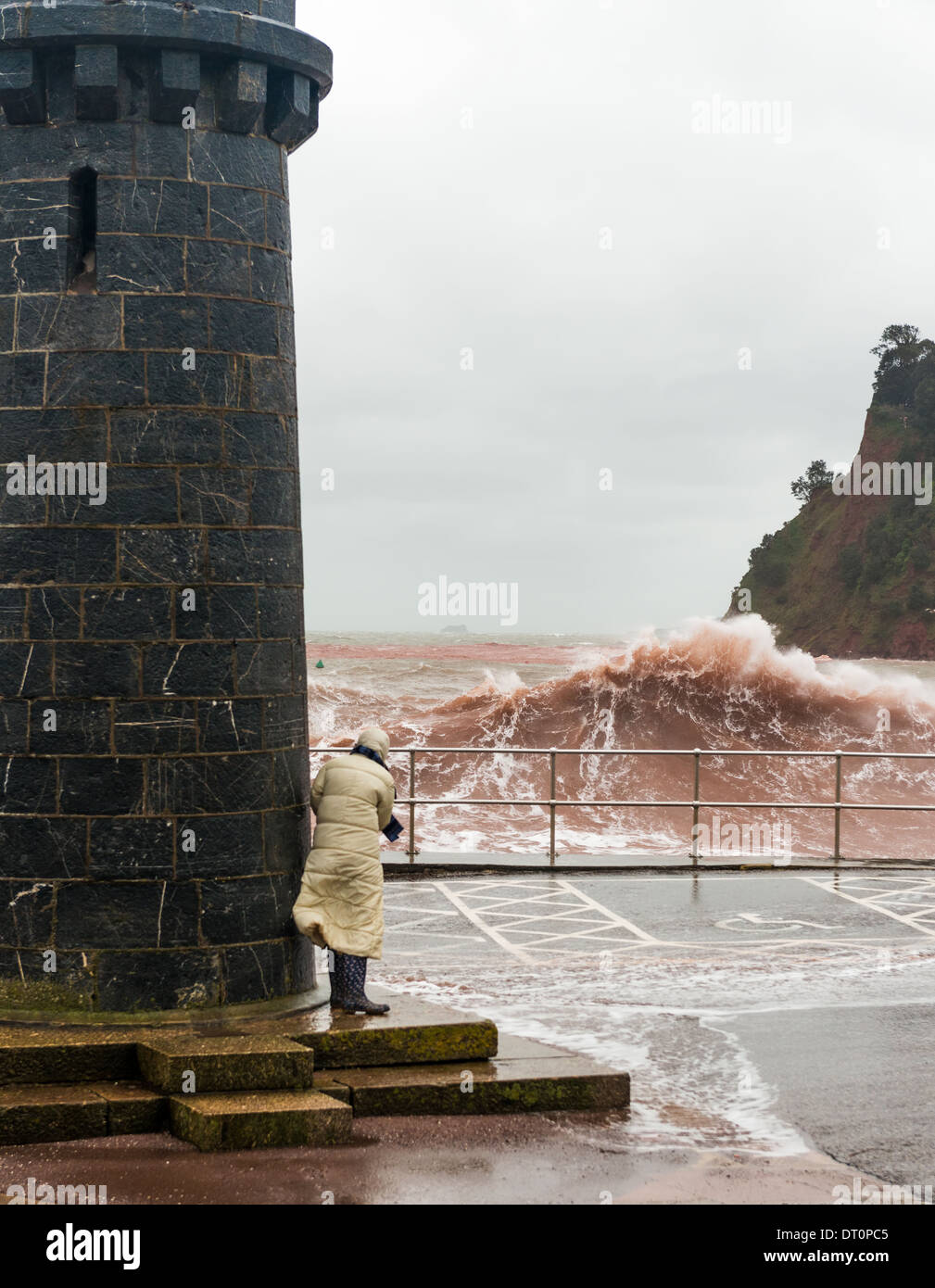 Teignmouth, Devon, England. February 2014. A woman hides behind the ...