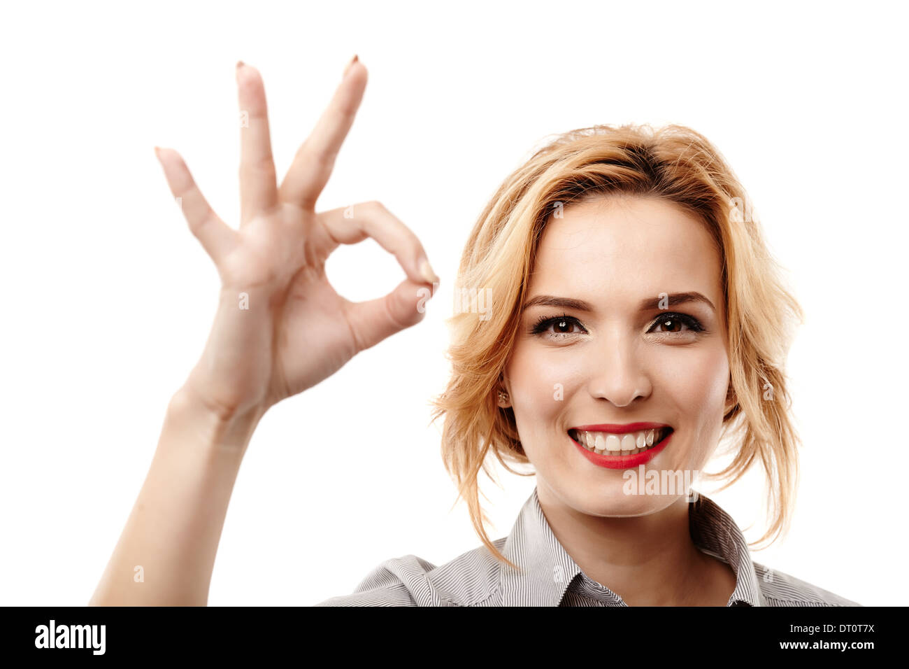 Closeup of young cheerful businesswoman making the ok sign, isolated on ...