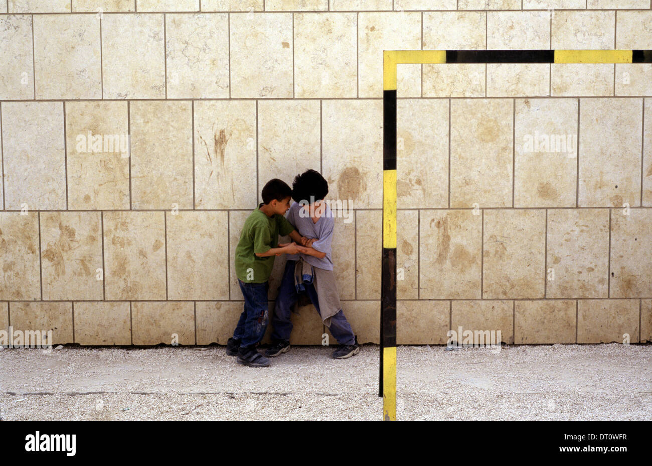 Young Israeli Jewish and Arab kid playing at the playground courtyard ...