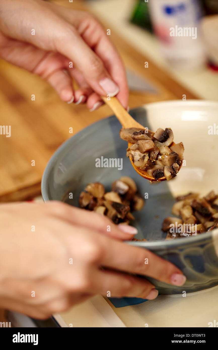 Closeup of a woman cook's hands preparing sliced, diced and cooked ...