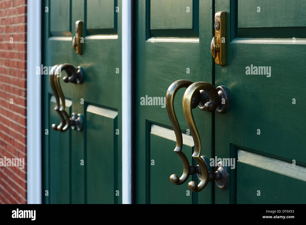 Bronze handles cast shadows on the green door Stock Photo - Alamy
