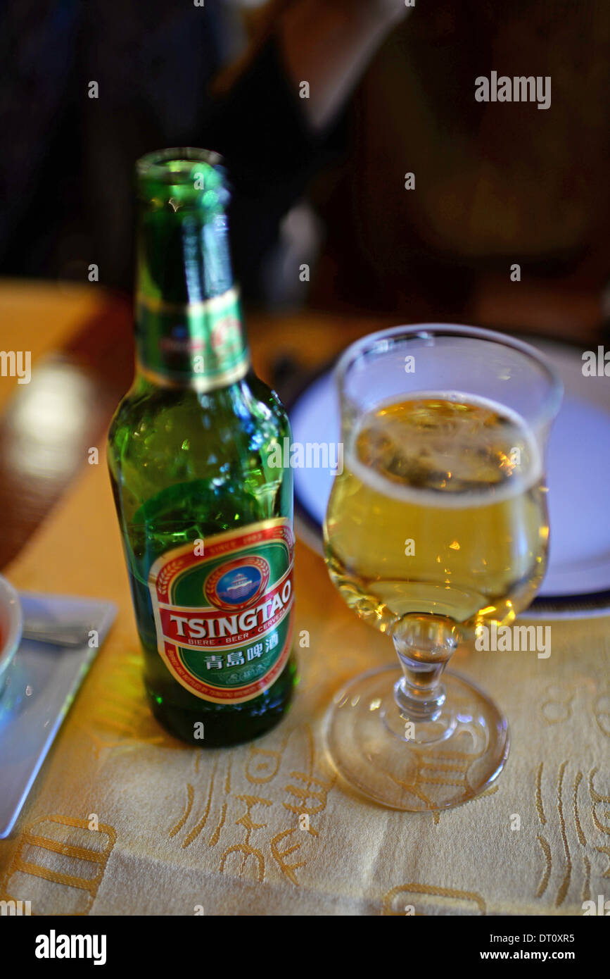 Bottle of Tsingtao Chinese beer and full glass on restaurant table ...