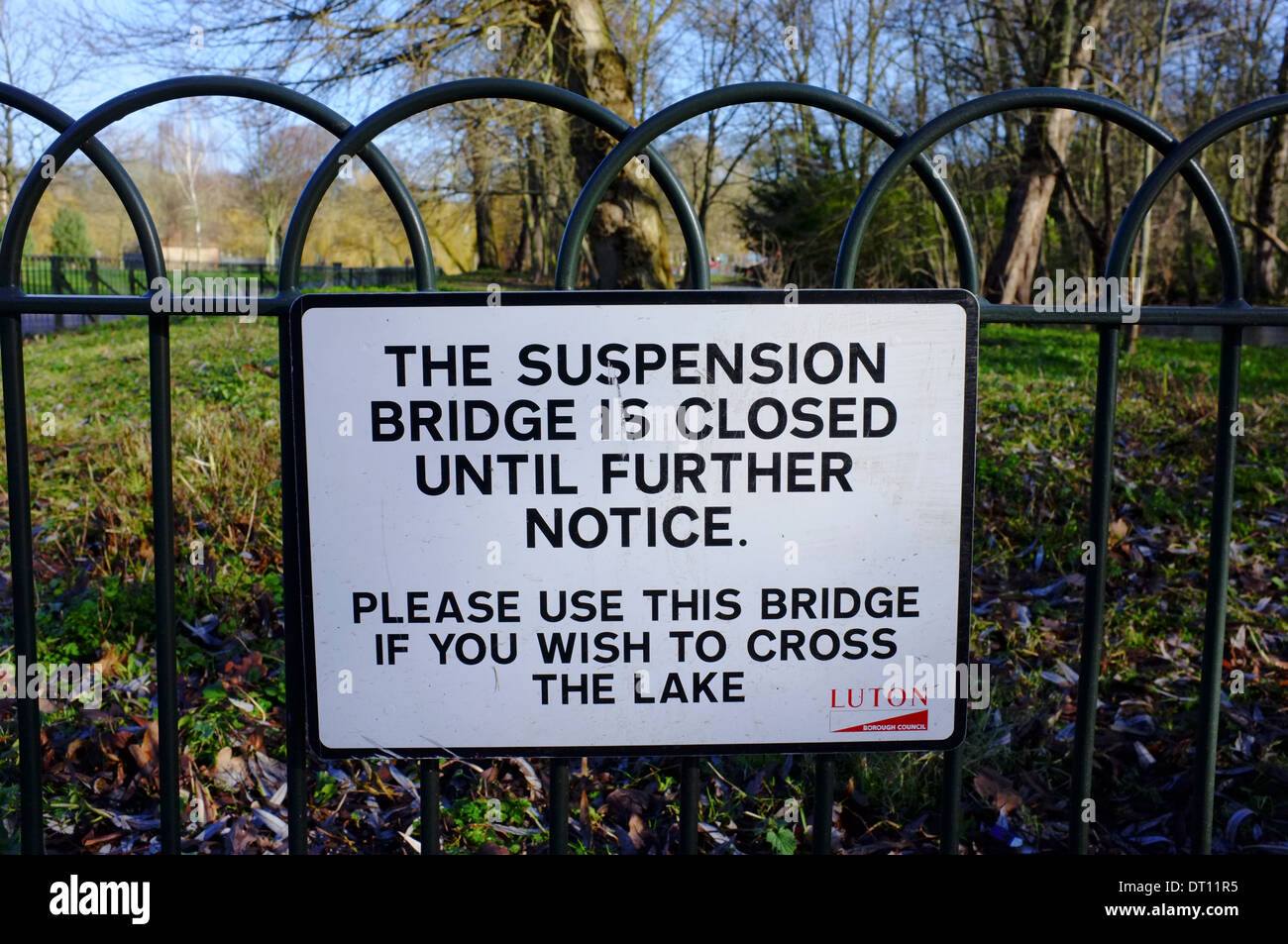 Notice warning of bridge closure on iron fence in Wardown Park, Luton ...