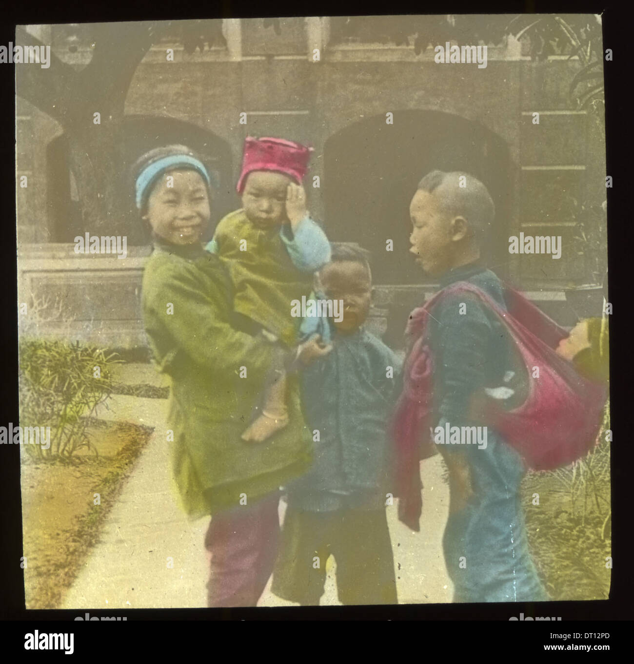A photograph showing five children standing outdoors on a path near a ...