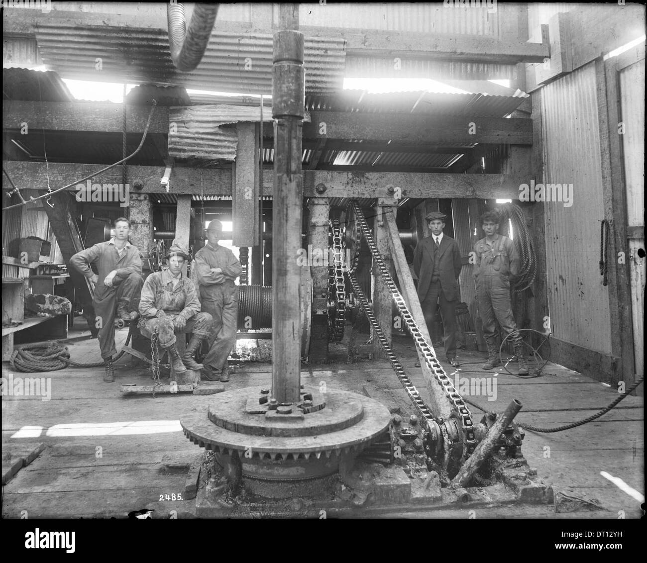 Five workmen standing around the rotary drill system in action, Brayer ...