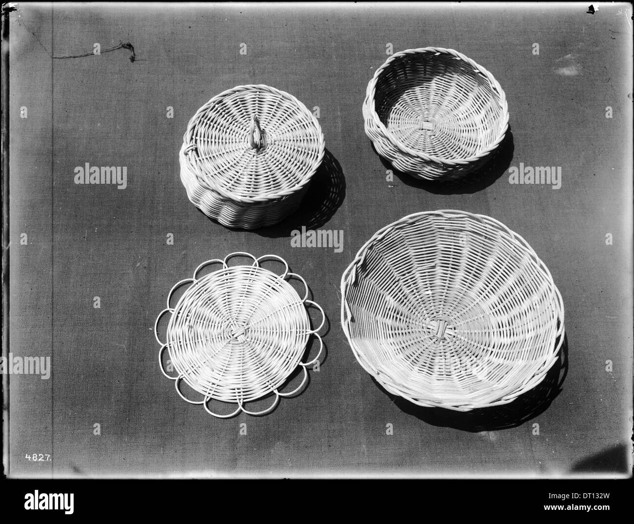 Four Native American baskets are displayed against a cloth backdrop ...