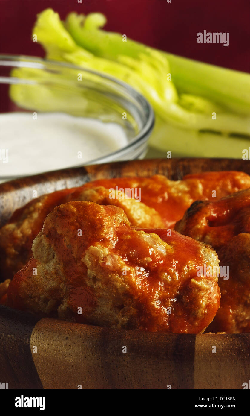 Chicken Wings in a wooden bowl with dipping sauce and celery Stock ...