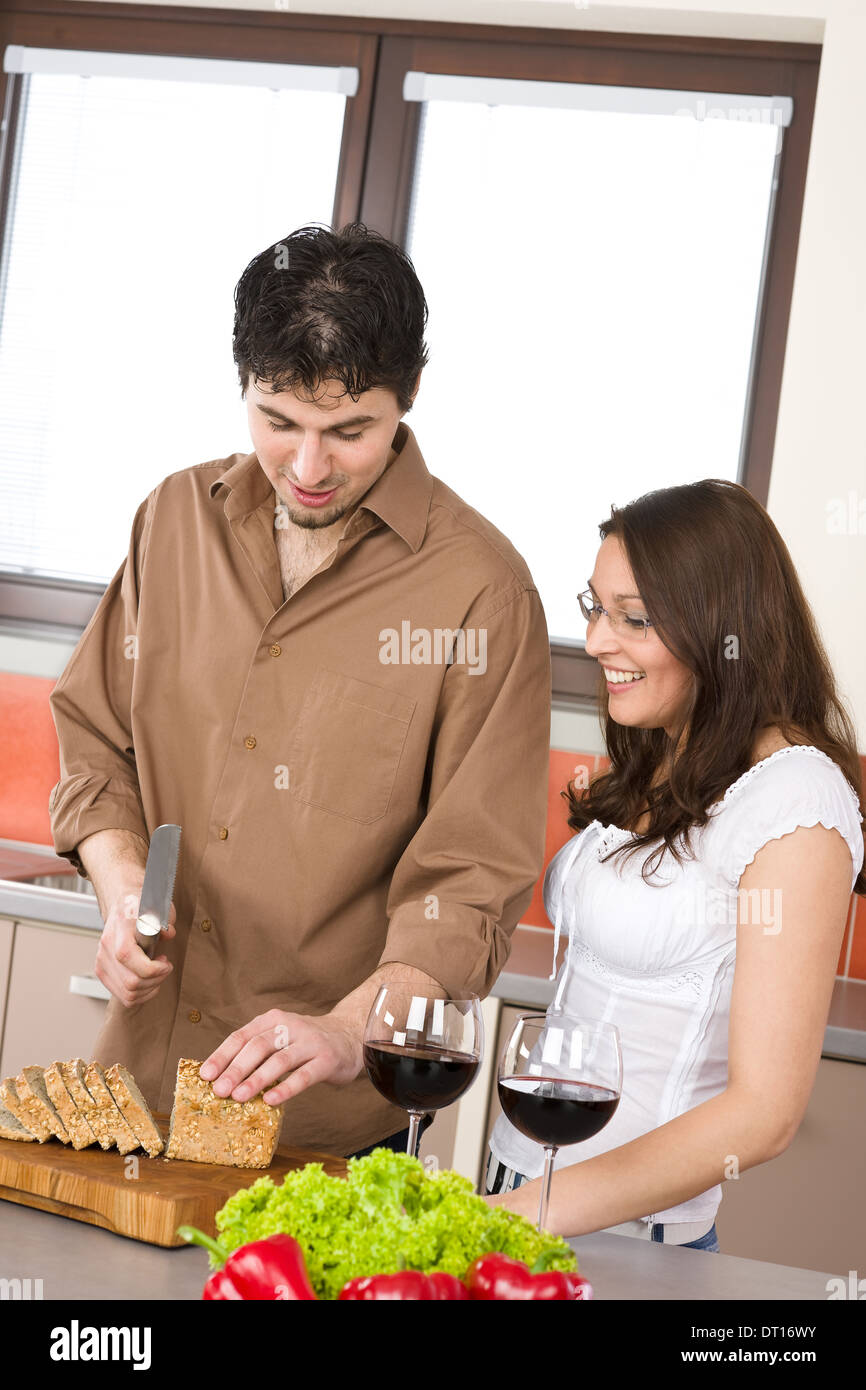 Happy couple cut bread in modern kitchen Stock Photo - Alamy
