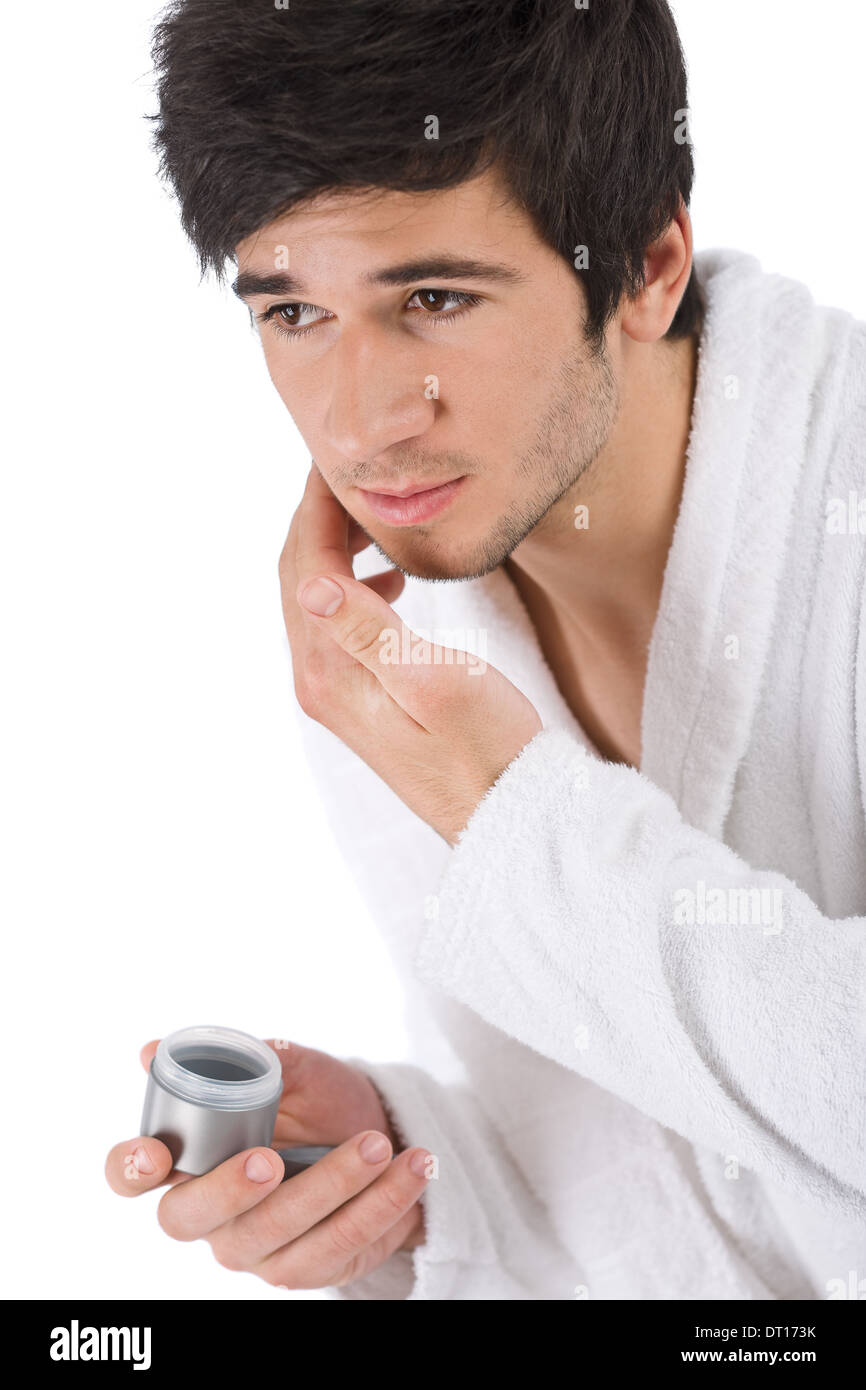 Facial care - Young man applying moisturizer Stock Photo - Alamy