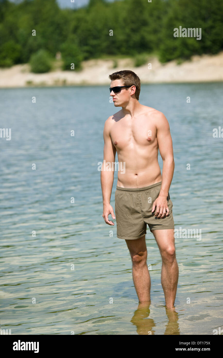 Man enjoy sun at seashore standing in water Stock Photo - Alamy