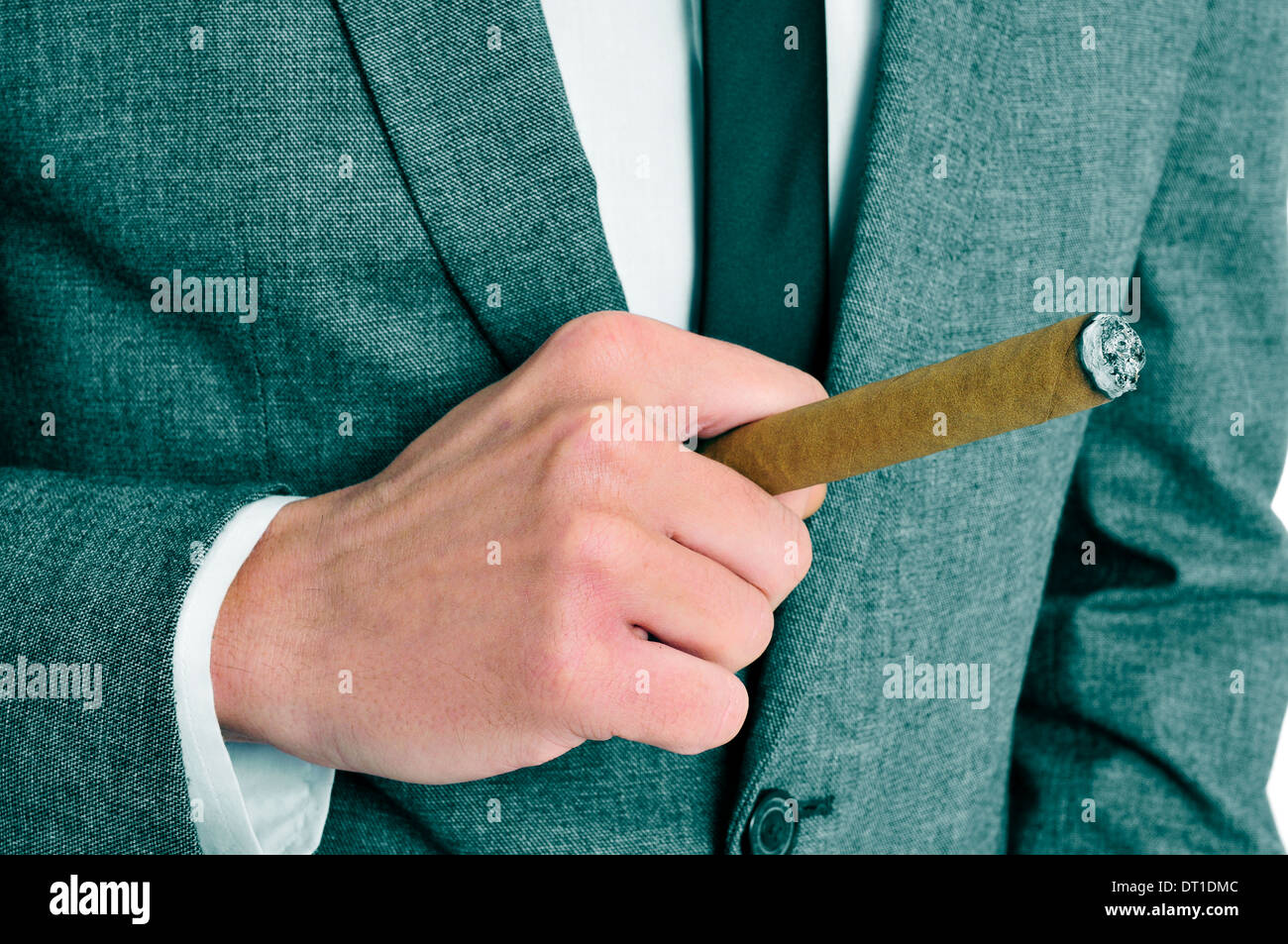 a man wearing a suit smoking a cigar Stock Photo - Alamy