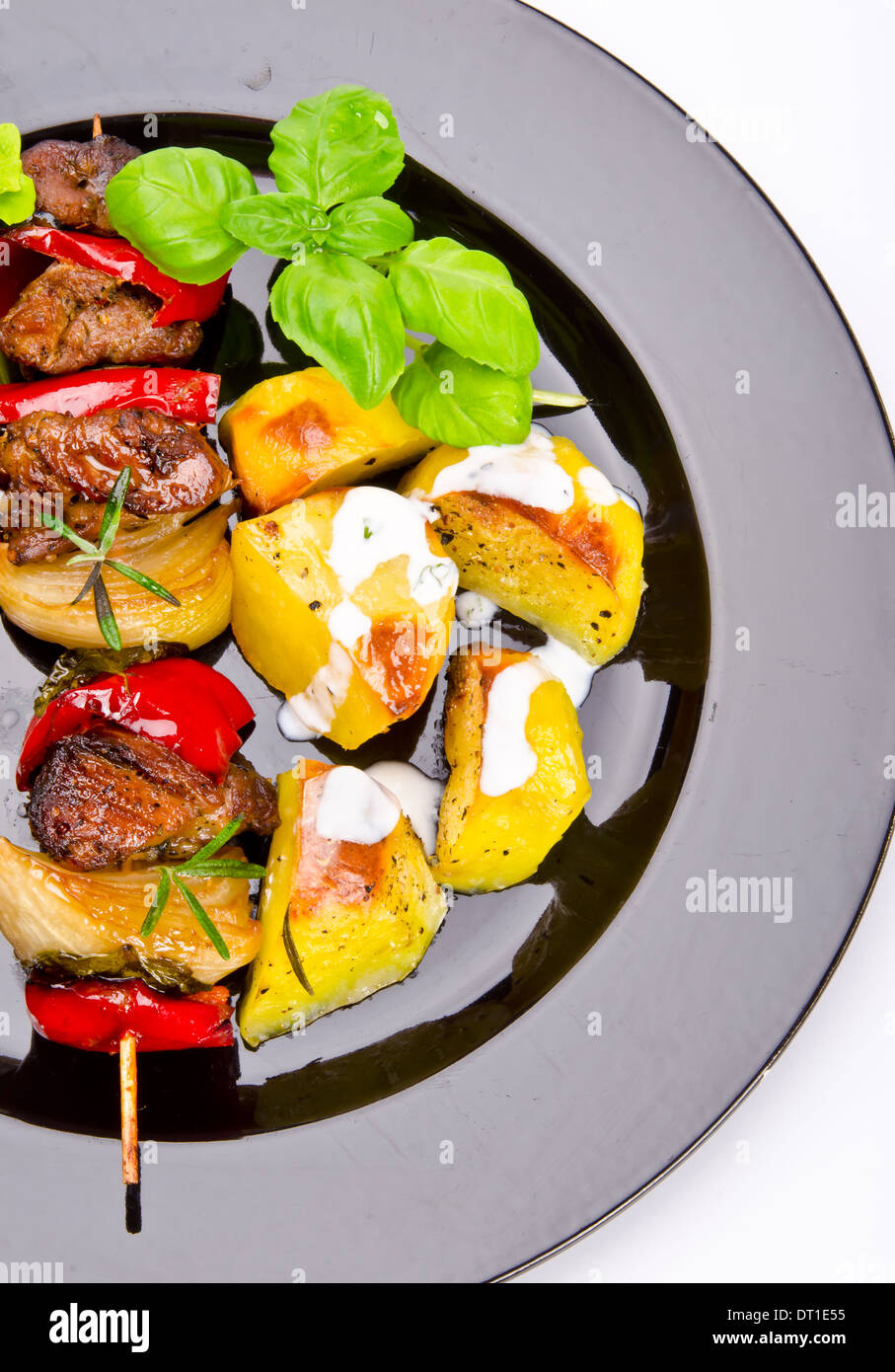 Meat spit with fried potatoes Stock Photo - Alamy