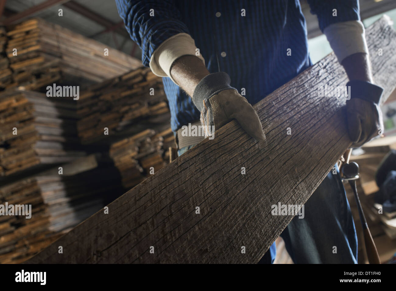 A heap of recycled reclaimed timber planks of wood in a timber yard A ...