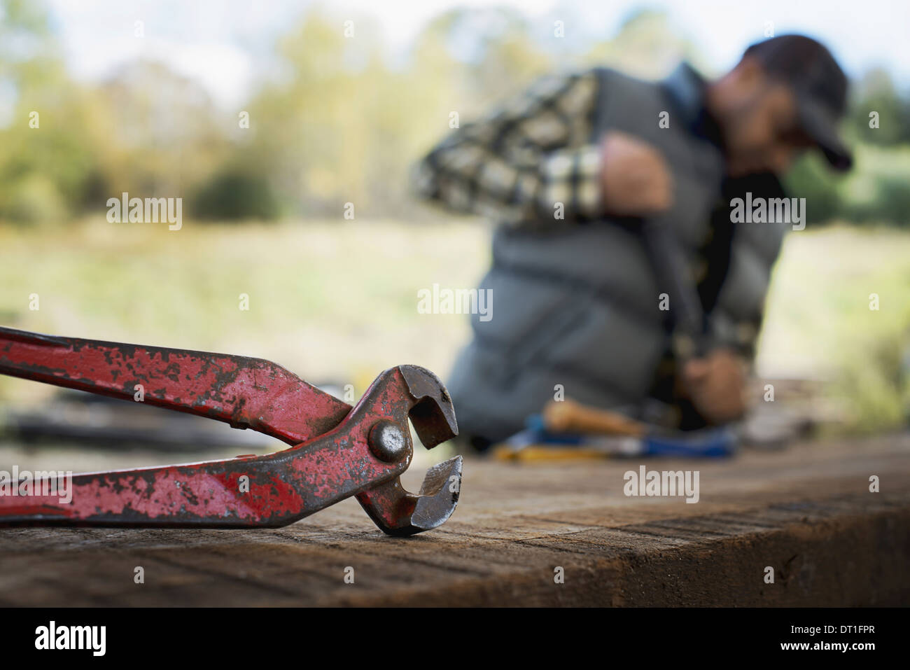 A reclaimed lumber workshop A man preparing the timber by removing all ...