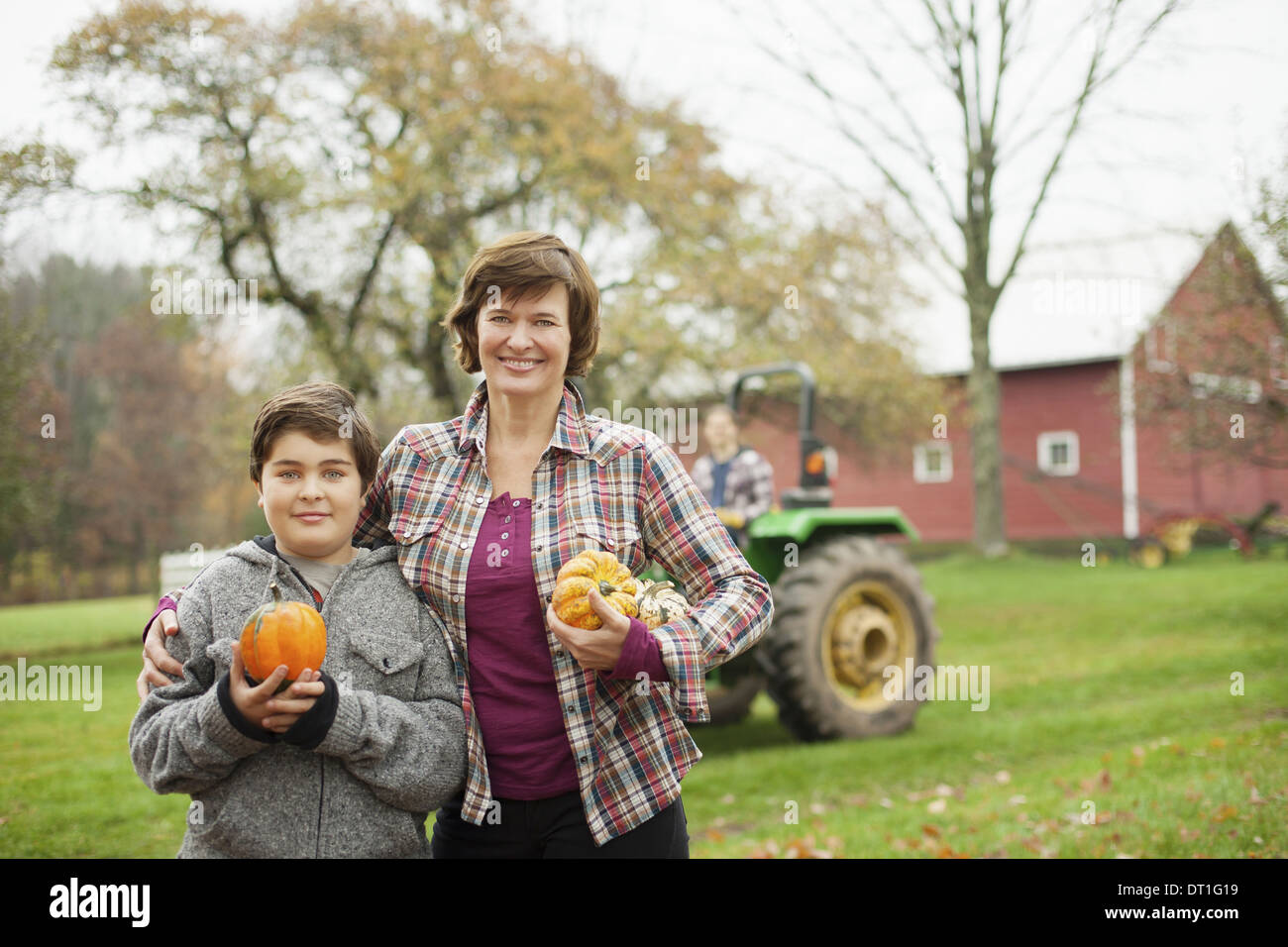 Two people a woman and a child on an organic farm carrying harvested ...