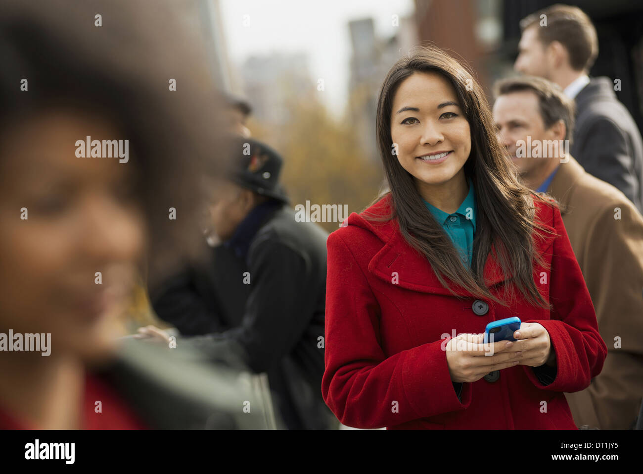 using mobile phones and talking to each other Two women and two men ...