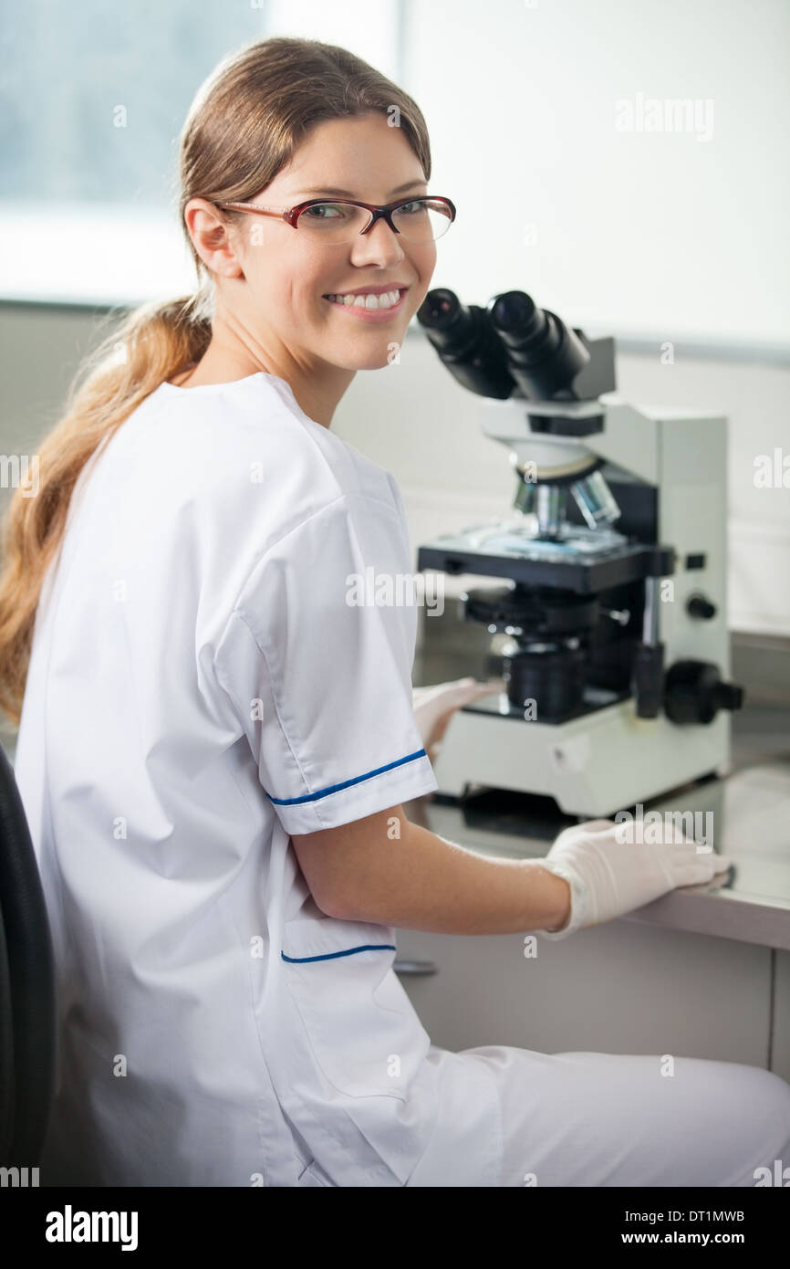 Confident Female Scientist Using Microscope In Lab Stock Photo - Alamy