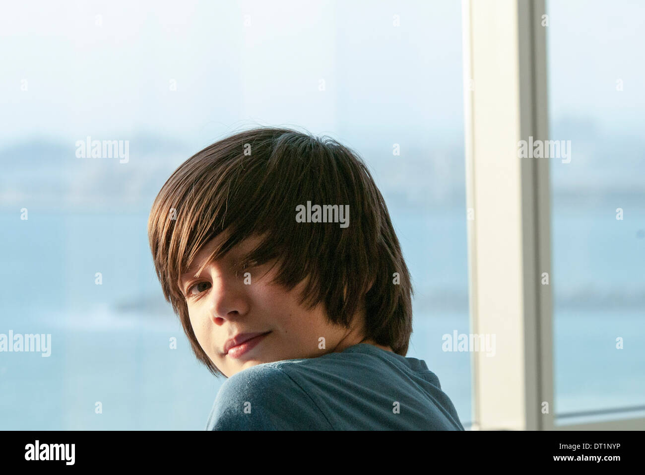 Teenage boy smiling over shoulder, portrait Stock Photo - Alamy