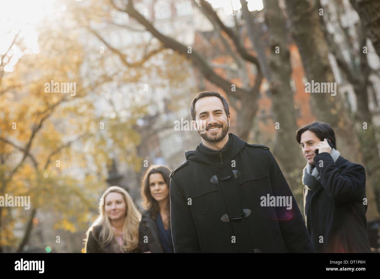 Adult group in urban park man in front Stock Photo - Alamy