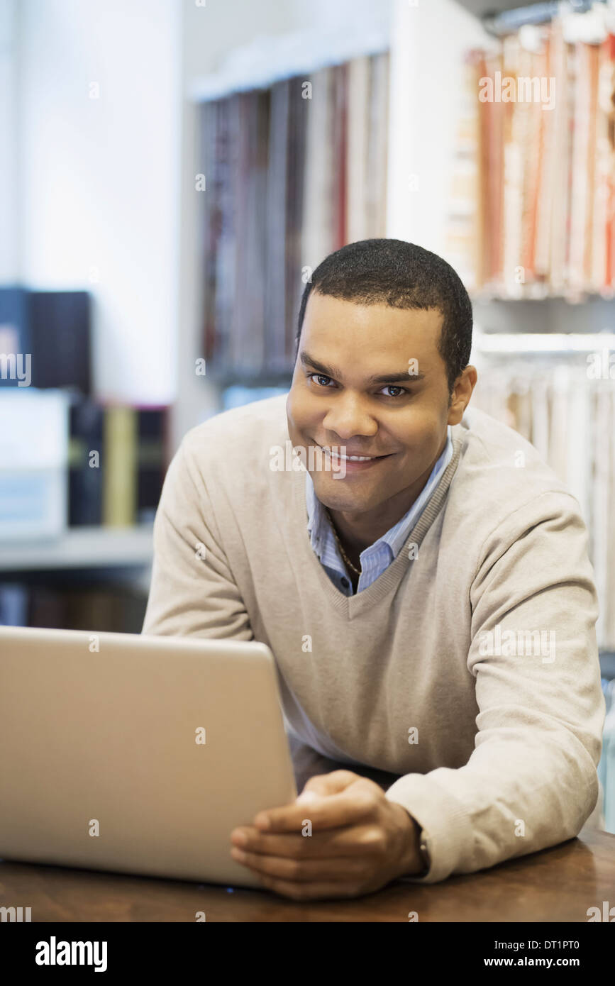 Man working in design shop with laptop Stock Photo - Alamy