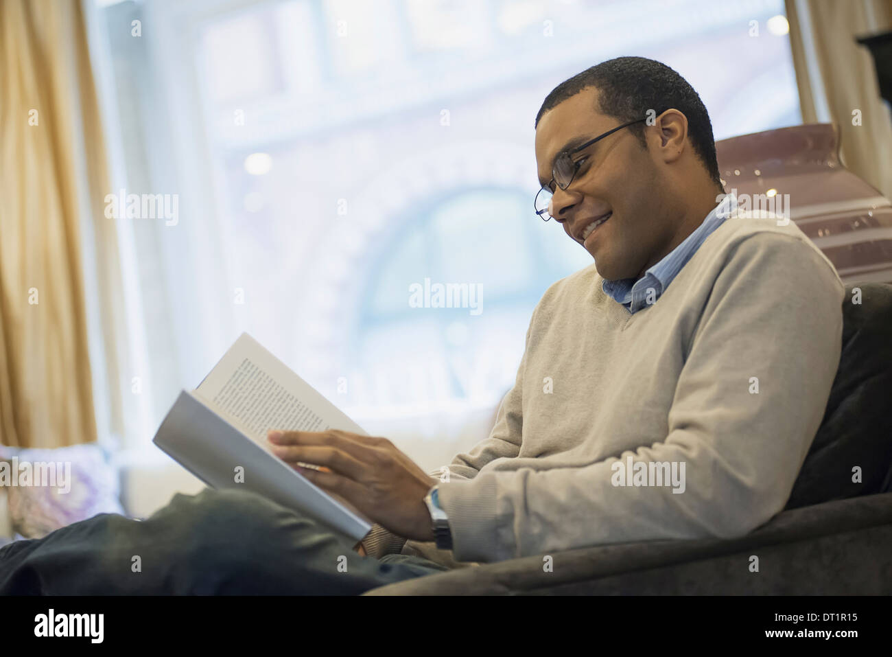 Man relaxing at home reading Stock Photo - Alamy