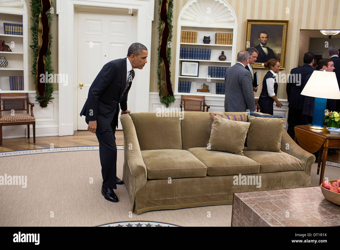 US President Barack Obama moves a sofa back into place following a ...