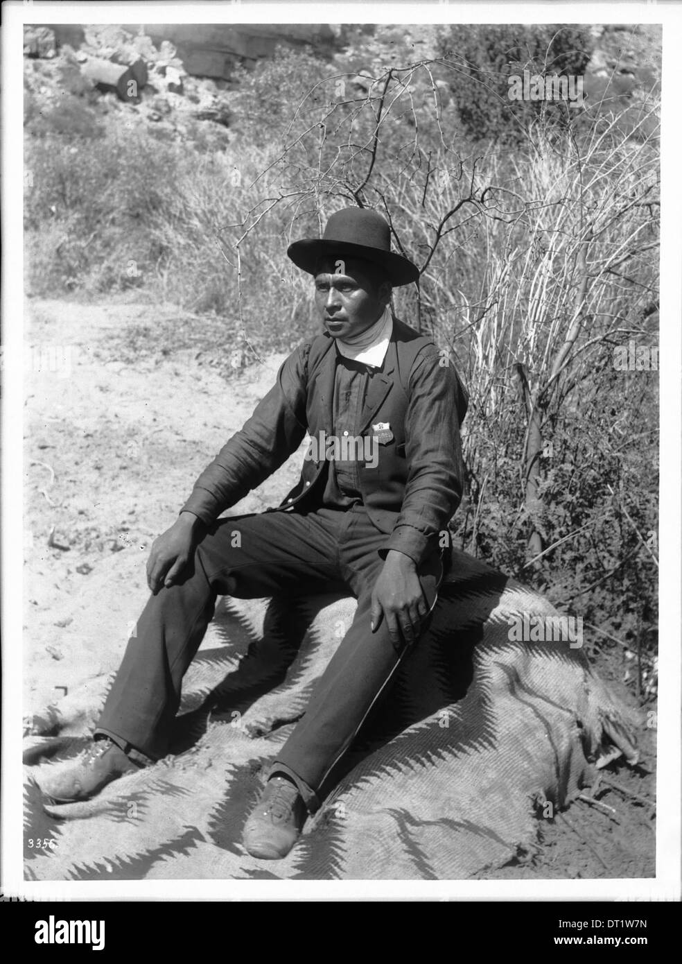A photograph of Lanoman, a Havasupai Indian policeman, sitting on a ...