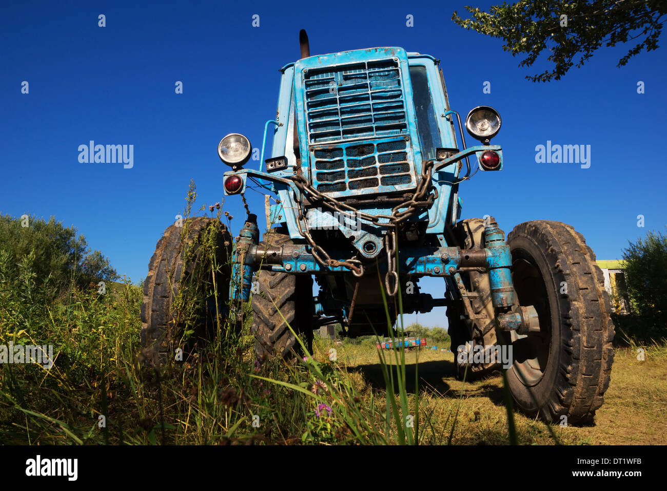 Blue wheeled agricultural tractor, dusty and rusty Stock Photo - Alamy