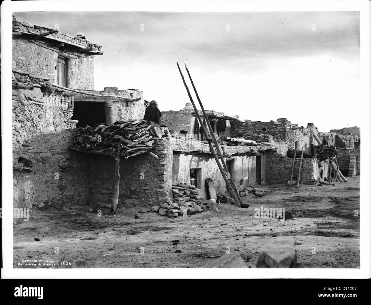 A Hopi Indian is shown atop adobe dwellings in the village of ...