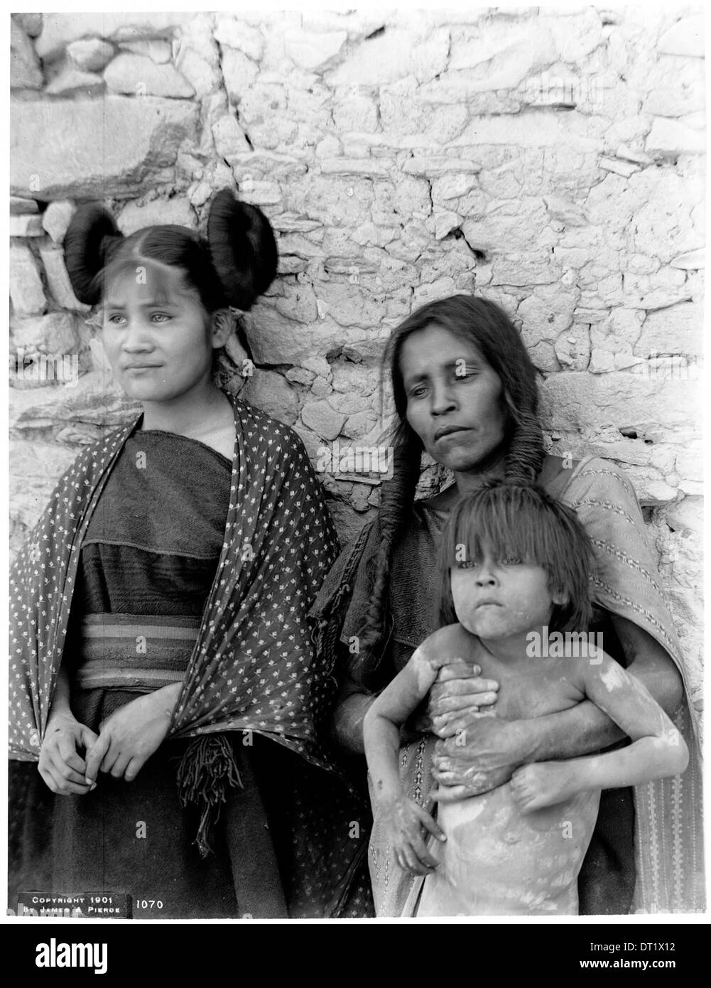 A Hopi Indian woman stands with her daughter and son in the village of ...