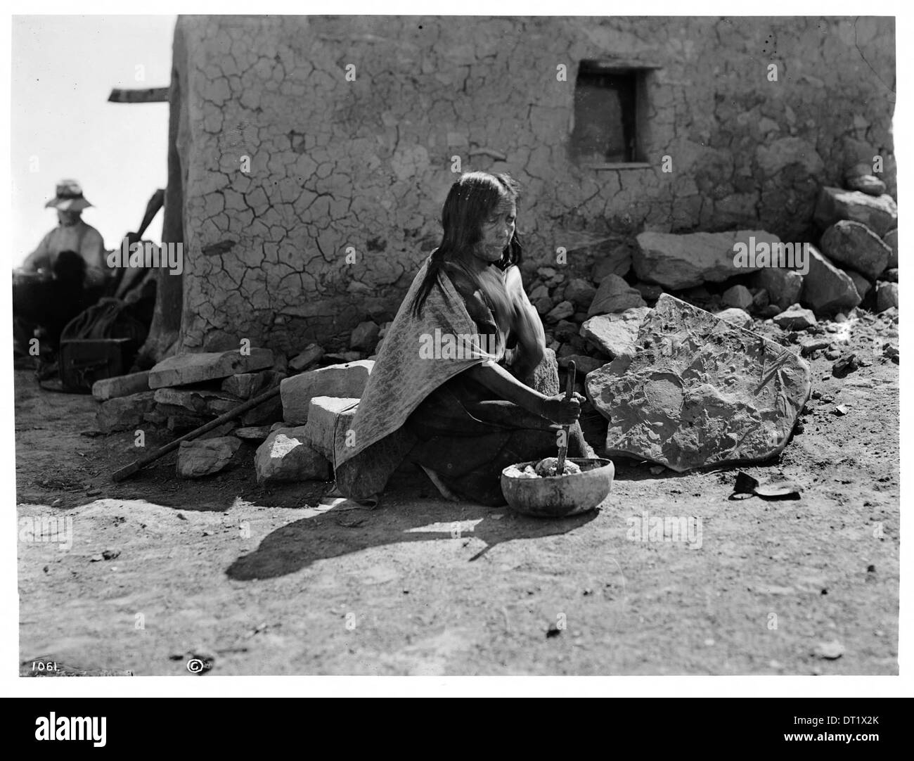 A photograph of a Hopi Indian woman mixing corn flour to make Piki ...