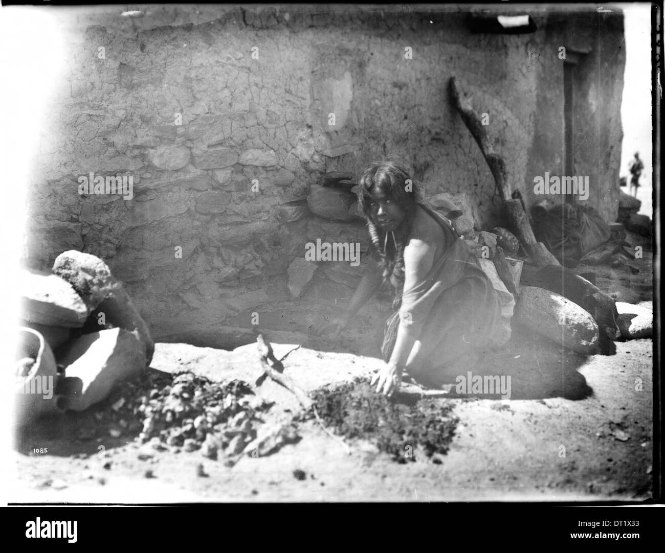 A photograph of a Hopi Indian woman sealing a piki oven before baking ...