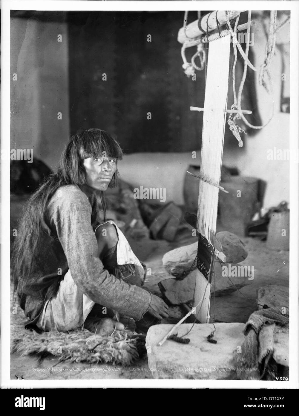 A Hopi man is shown weaving a kochina sash for a ceremonial kilt in ...