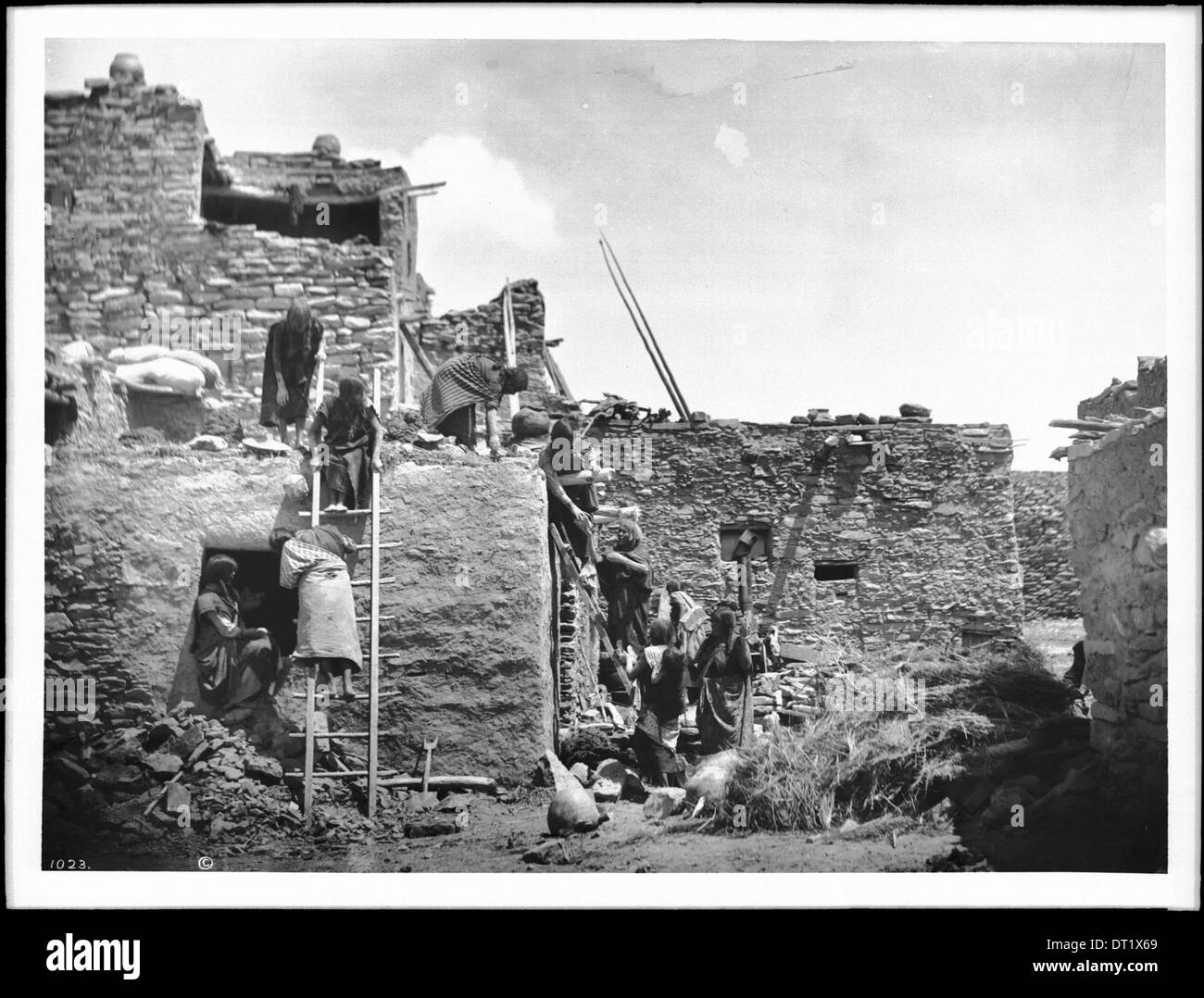 Photograph of Hopi women constructing a house in Oraibi. The image ...