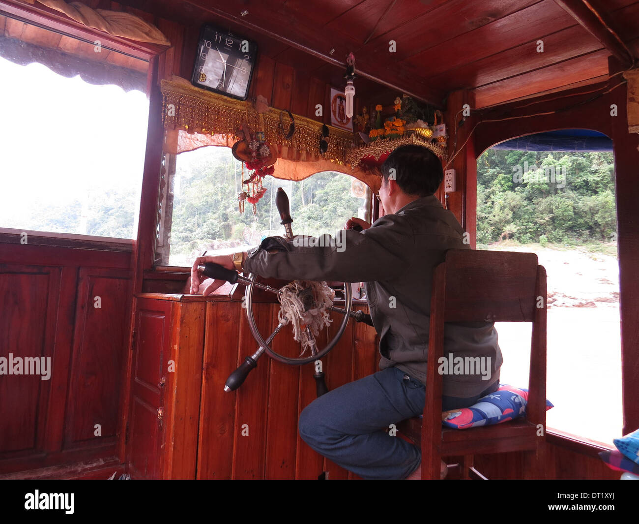 BOAT PILOT on the Mekong River in Laos. Photo Tony Gale Stock Photo - Alamy