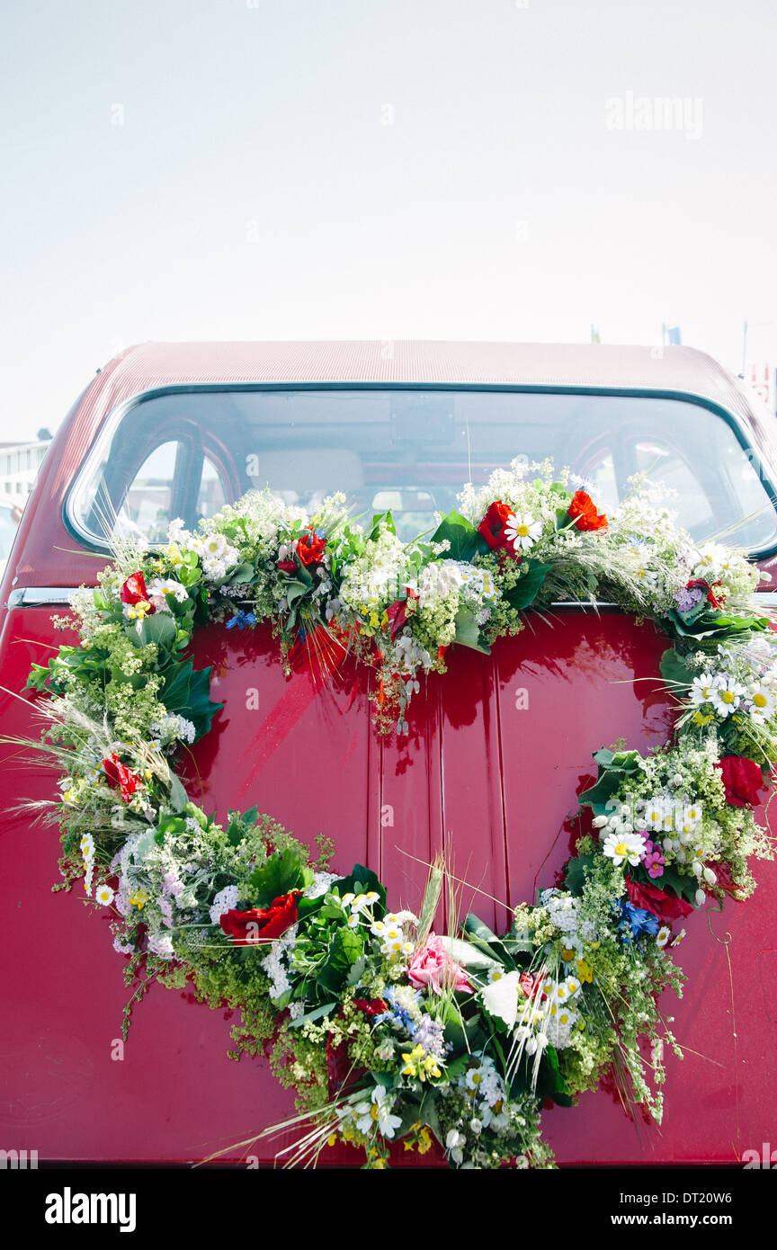 Heart shape bouquet on the rear end of a red wedding car Stock Photo ...
