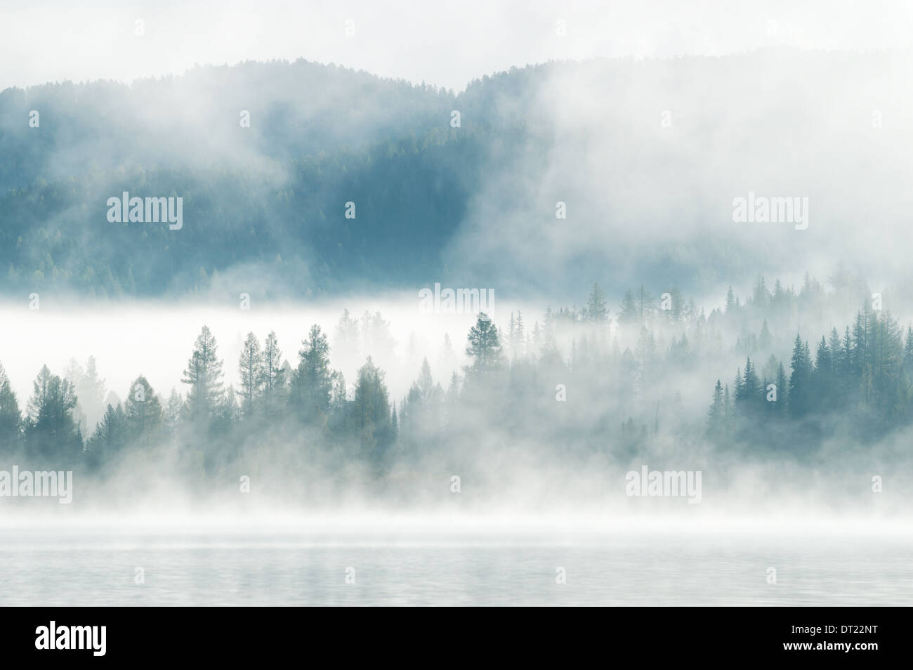 Heavy fog in the early morning on a mountain lake Early morning on ...