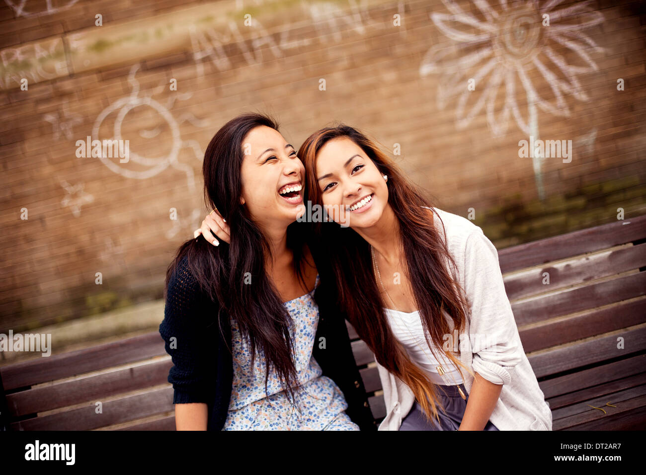 Teenage girls sitting on bench Stock Photo - Alamy