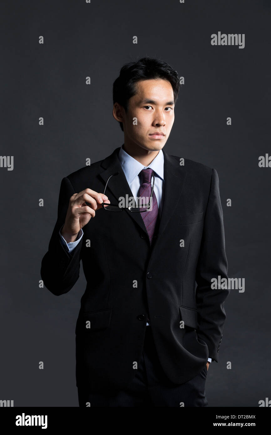 Stylish Chinese business man. In front of dark background Stock Photo ...
