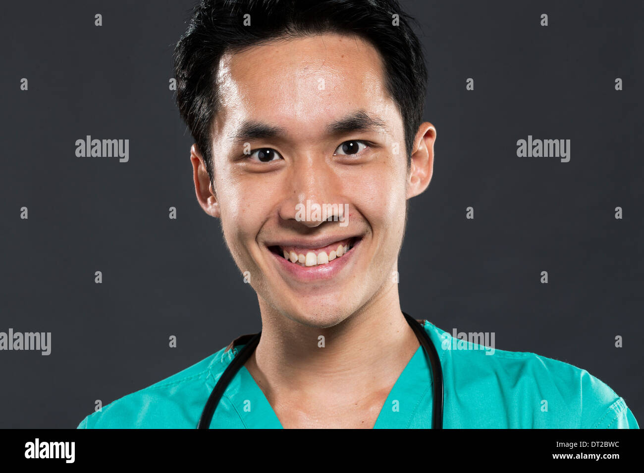 Closeup Portrait of a Male Asian doctor wearing Green Scrubs. Dark Grey ...