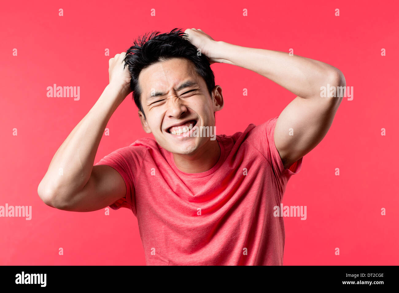 Close up Portrait of Asian man standing looking Anxious. Red background ...