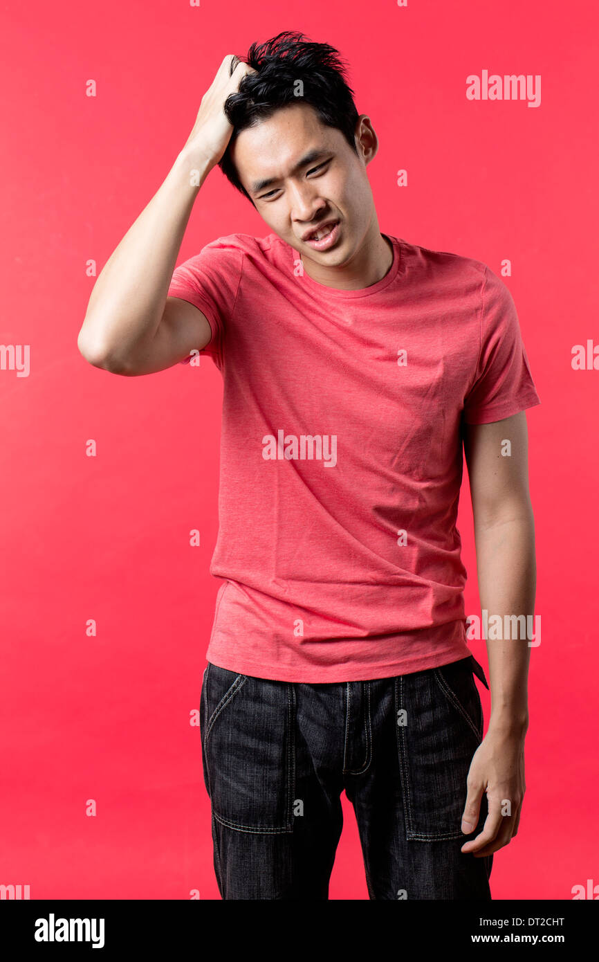 Portrait of Asian man standing looking Anxious. Red background Stock ...