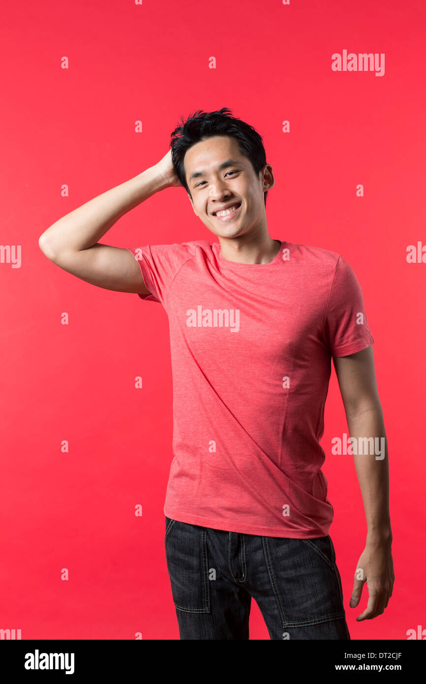 Portrait of a Happy Chinese man standing against red background Stock ...