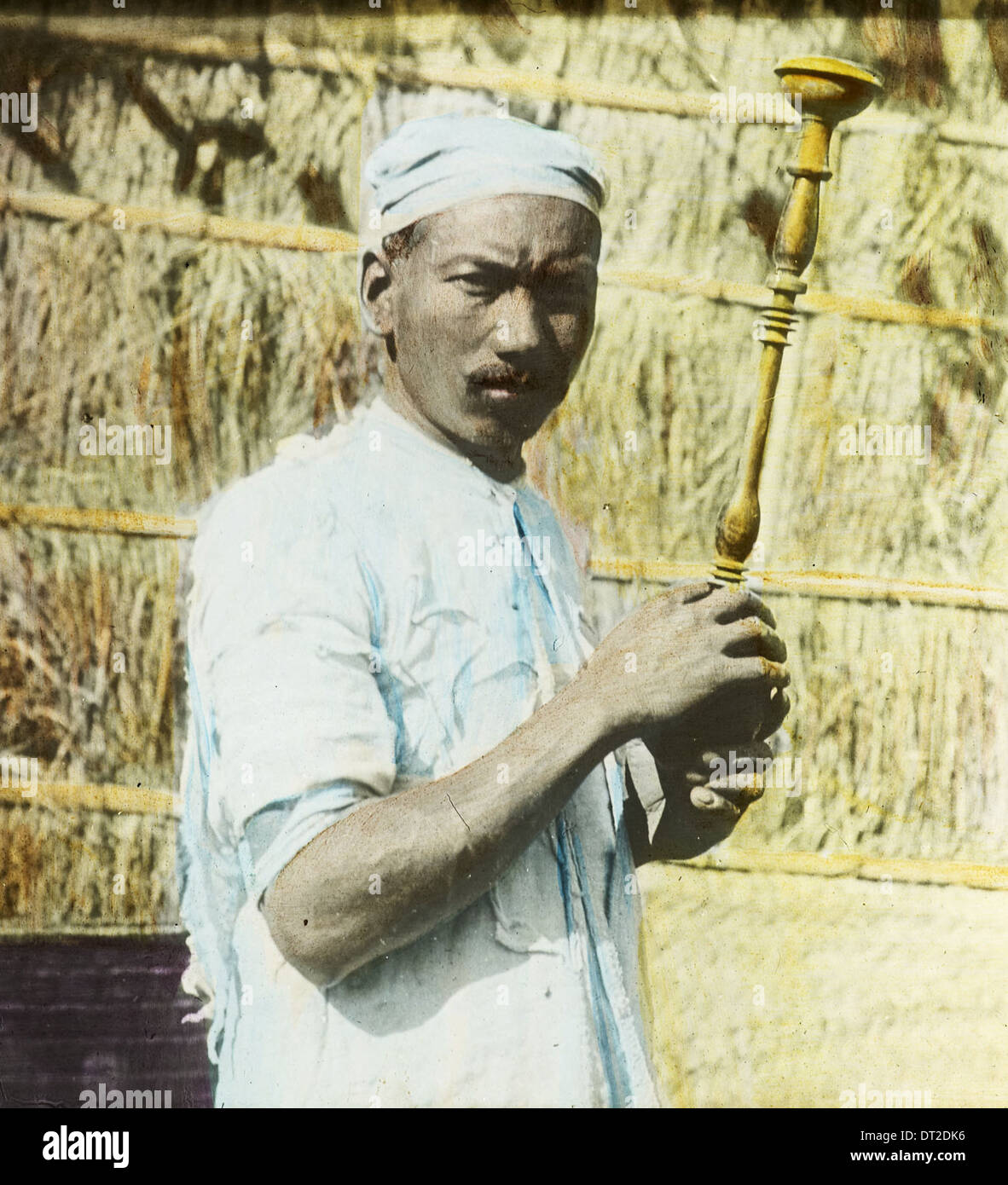 A man in India is shown with a wood-turned object, captured around 1920 ...