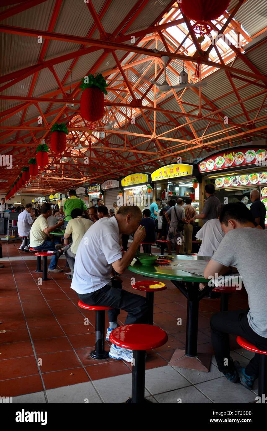 Diners sit and eat street food at outdoor tables Maxwell Food Center ...