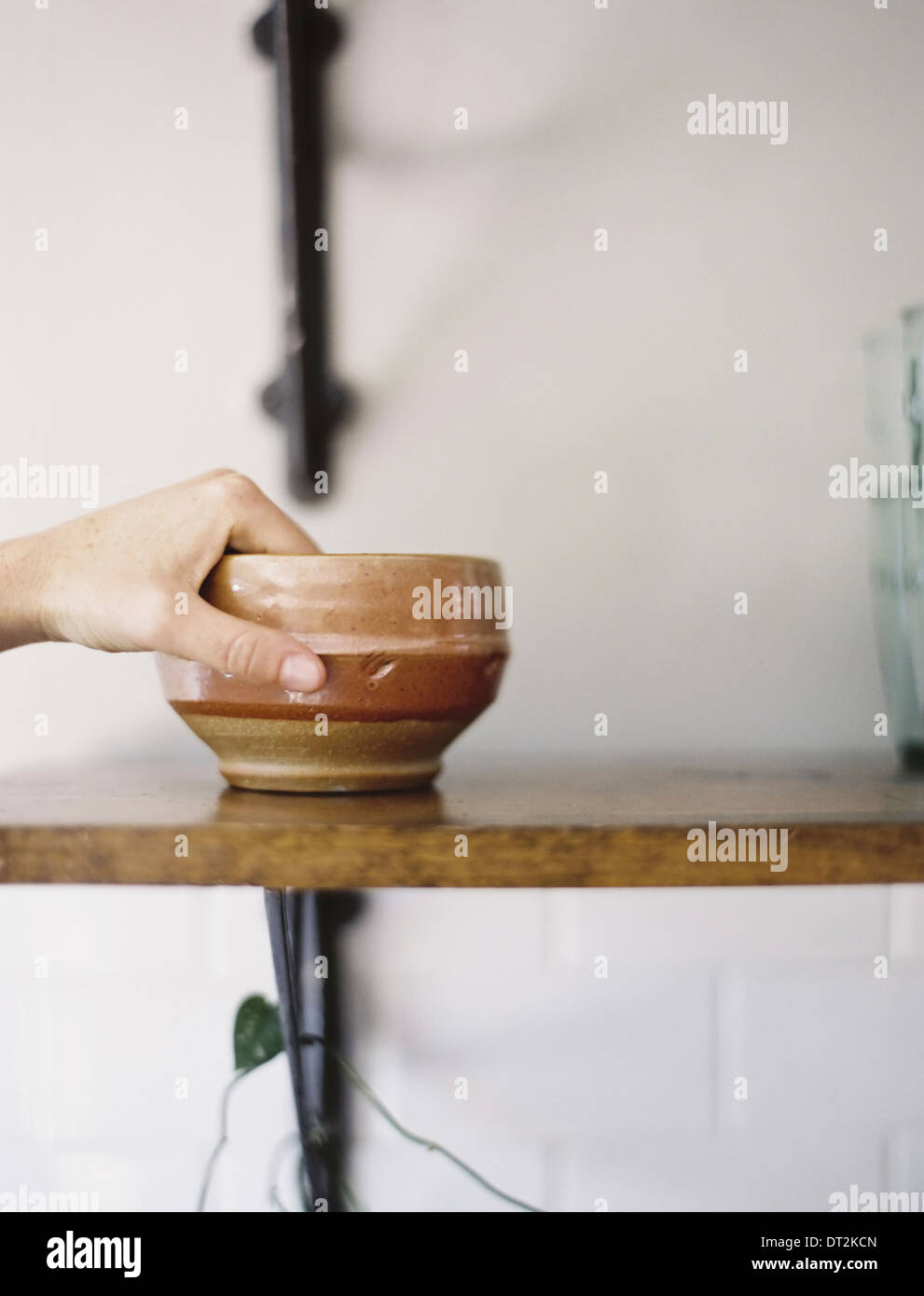 Farm to Table A person reaching up for a pottery bowl in a domestic ...