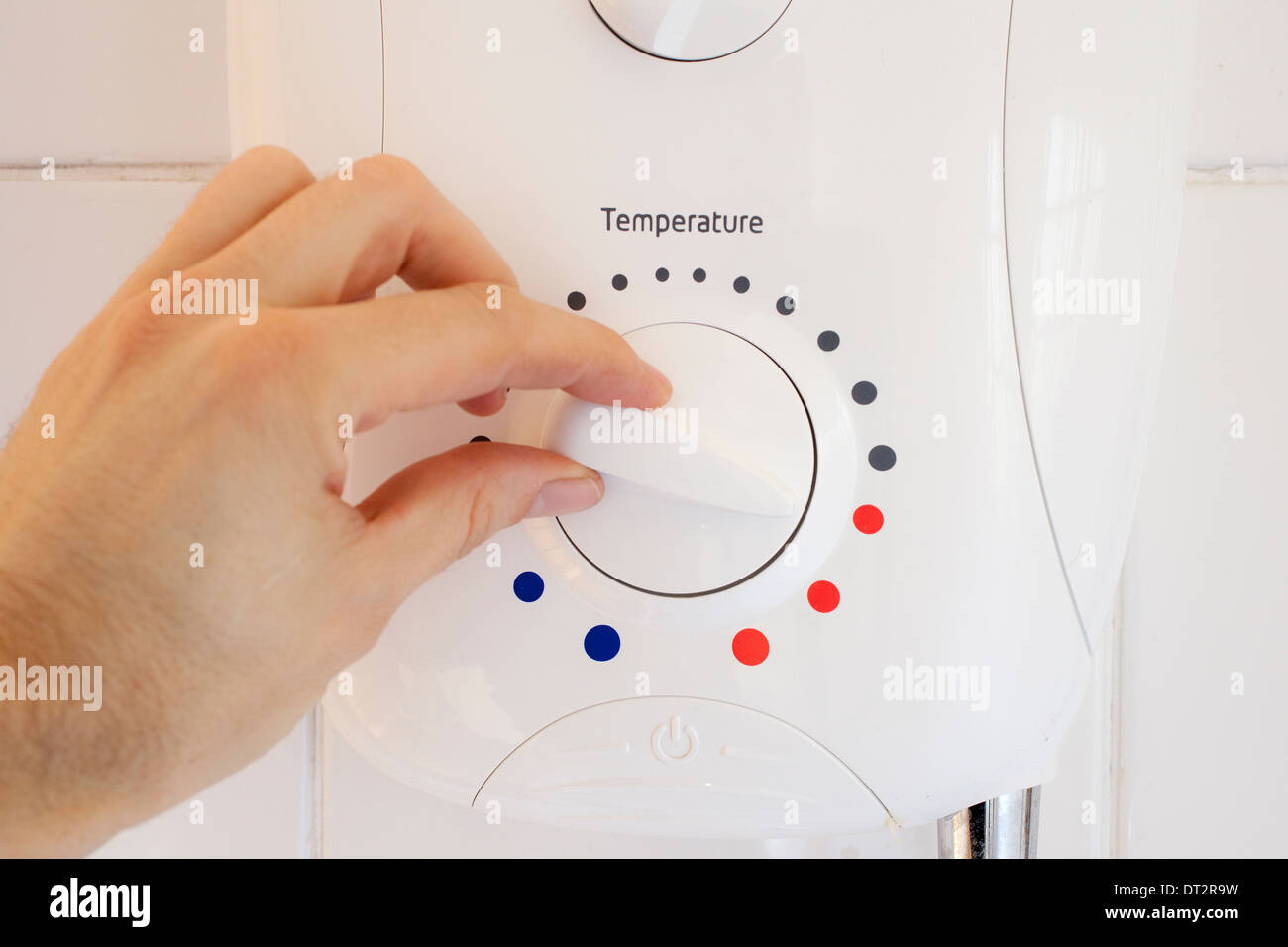 Hand turning up temperature dial Stock Photo - Alamy