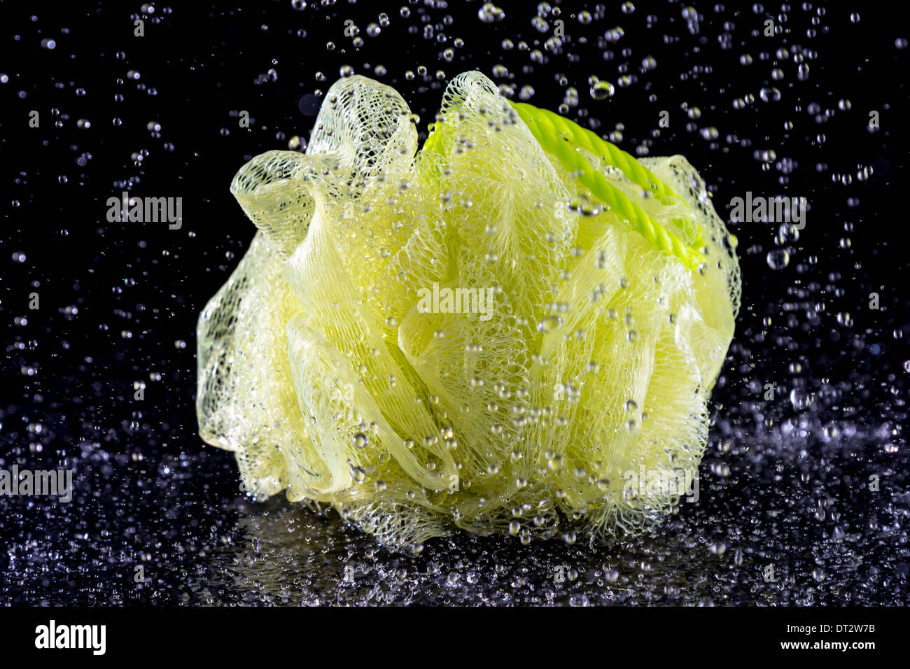Yellow Bath Sponge on reflecting black back- and unterground with water ...