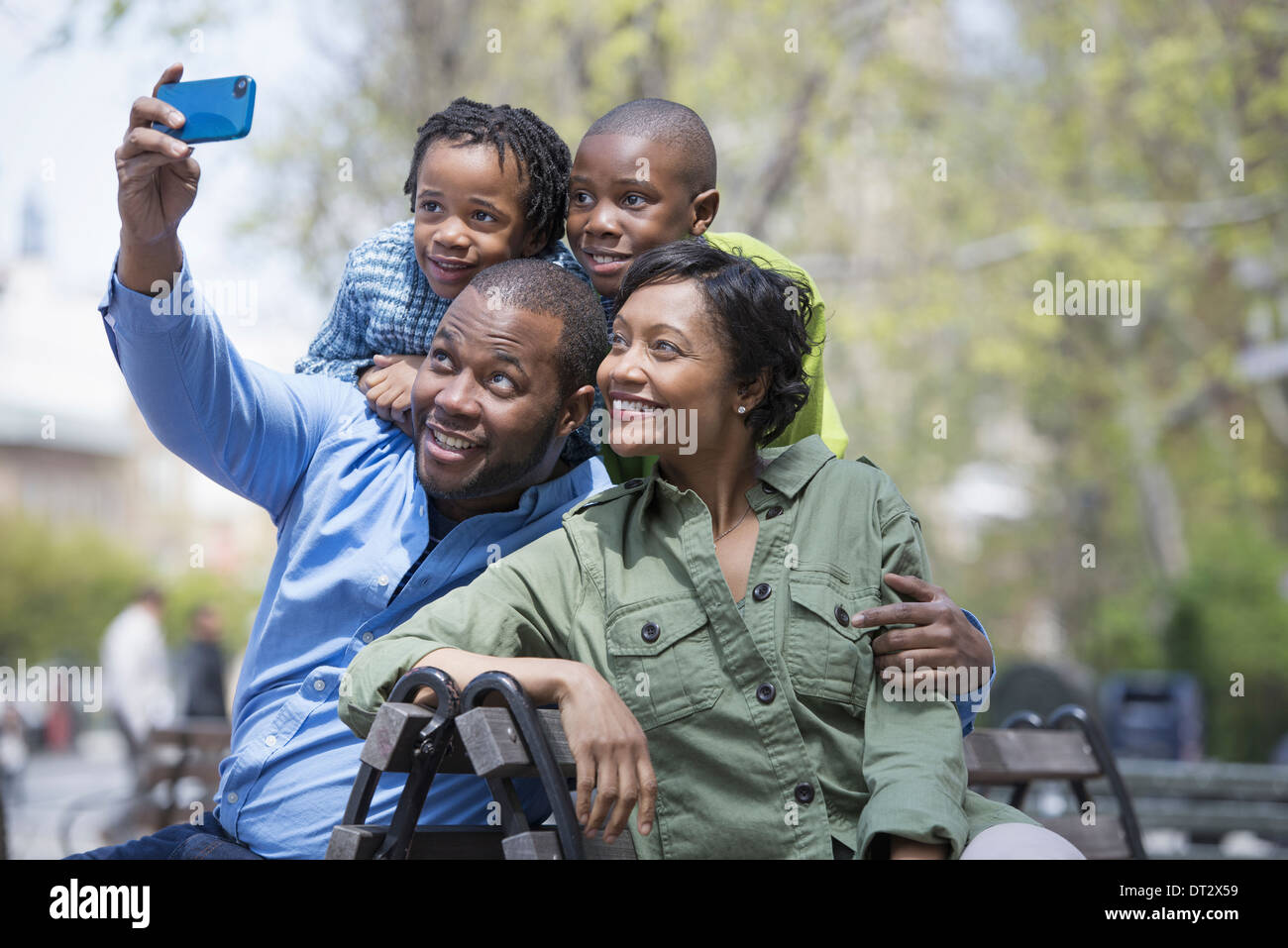 A family parents and two boys taking a photograph with a smart phone ...