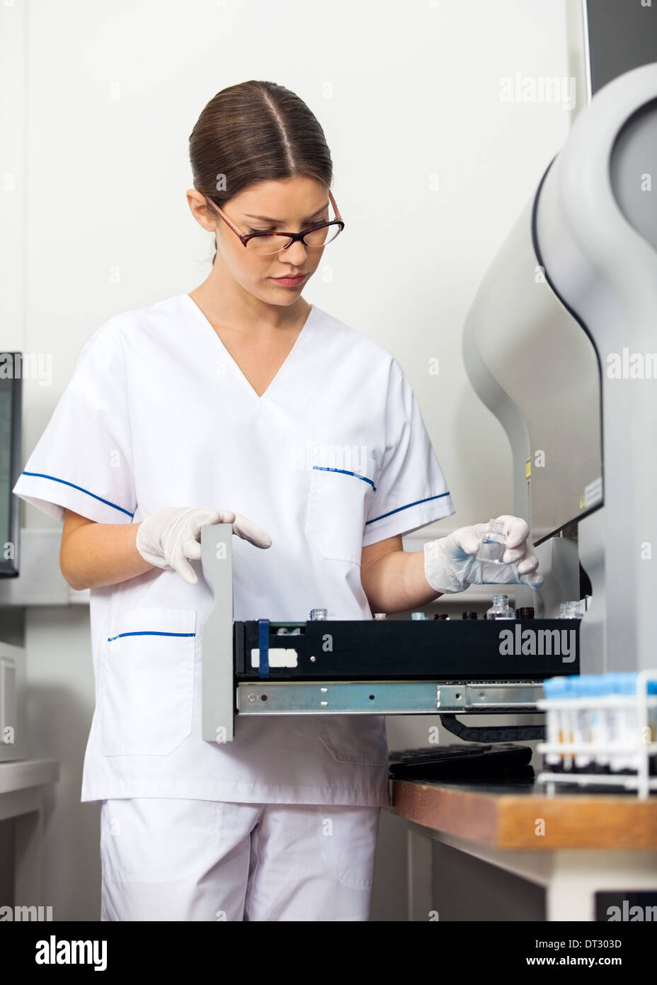 Researcher Loading Samples Into Analyzer In Lab Stock Photo - Alamy